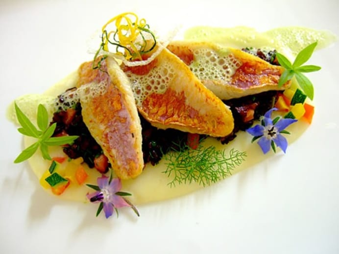 Mullet fillets and black rice with pistachio on sweet and sour sauce ...